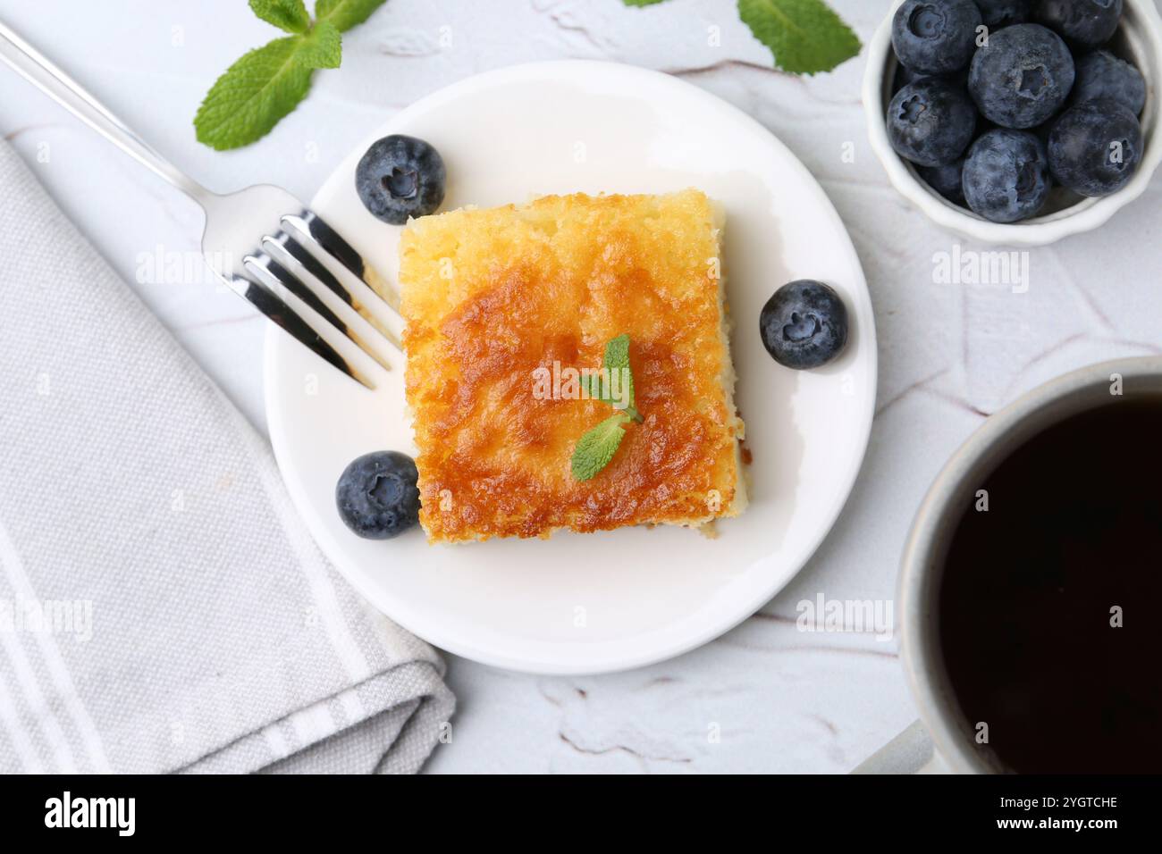 Slice of tasty semolina cake served on white textured table, flat lay ...