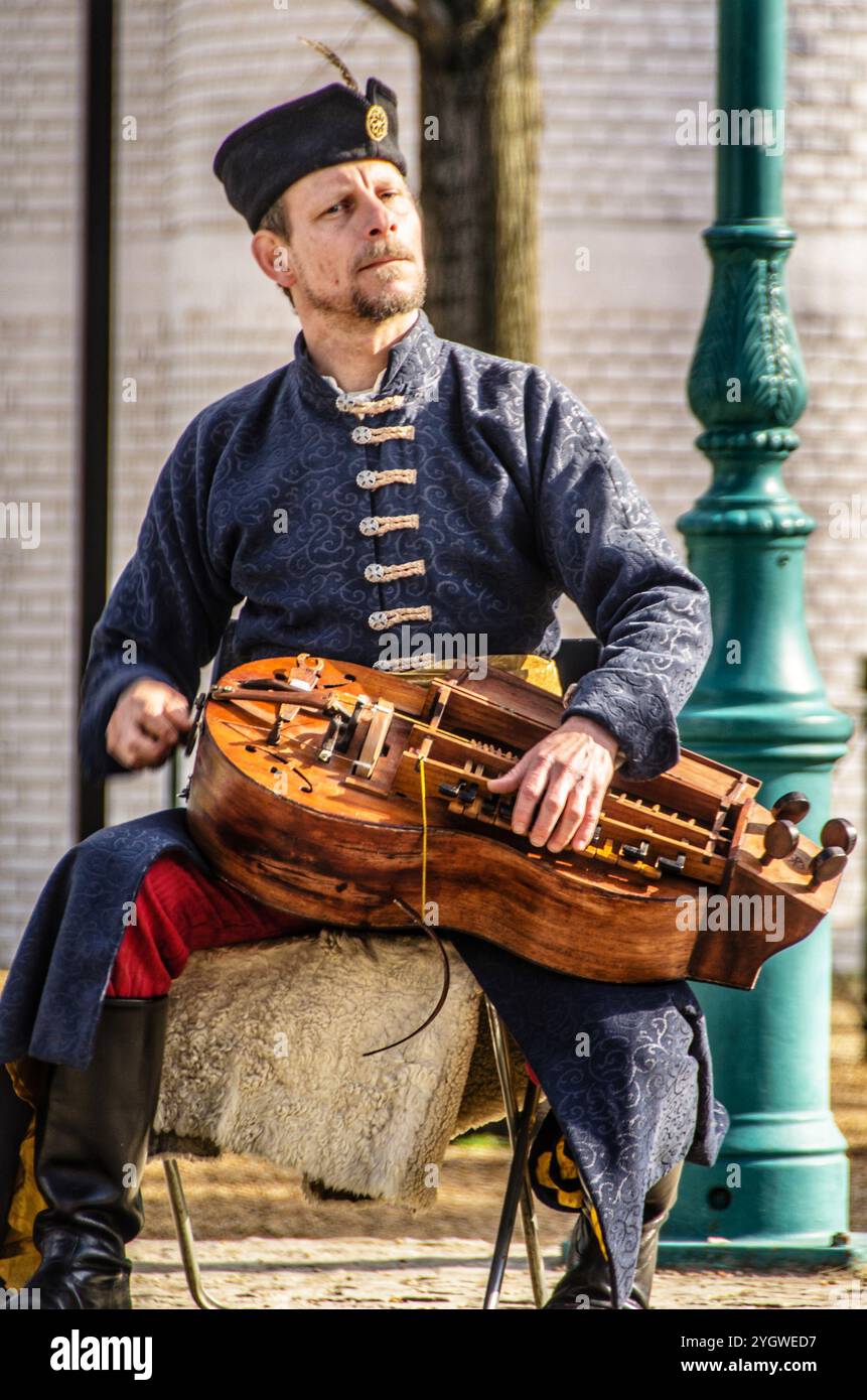 A skilled musician sits on a cozy chair in a public park, immersed in ...