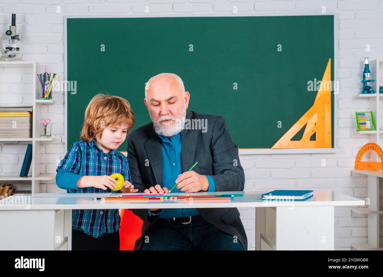 Individual teaching. Professor and pupil in classroom at the elementary ...