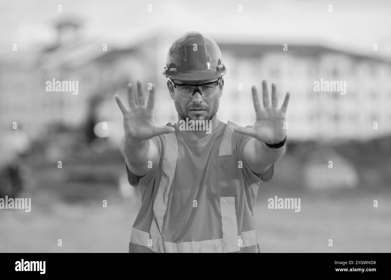 Worker with stop hand gesture. Builder in a hard hat working on a ...