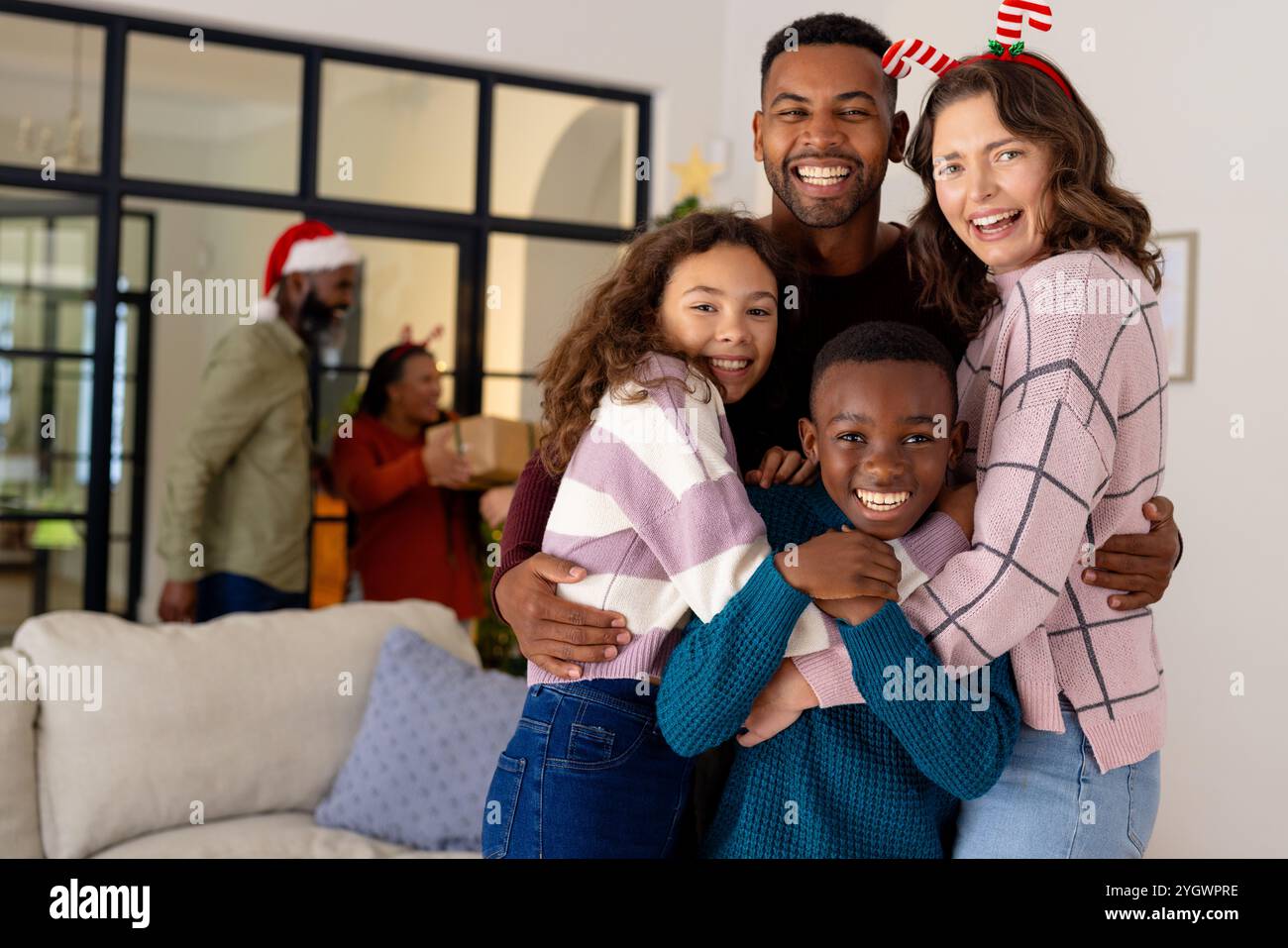 Happy multiracial family celebrating Christmas at home, hugging and ...