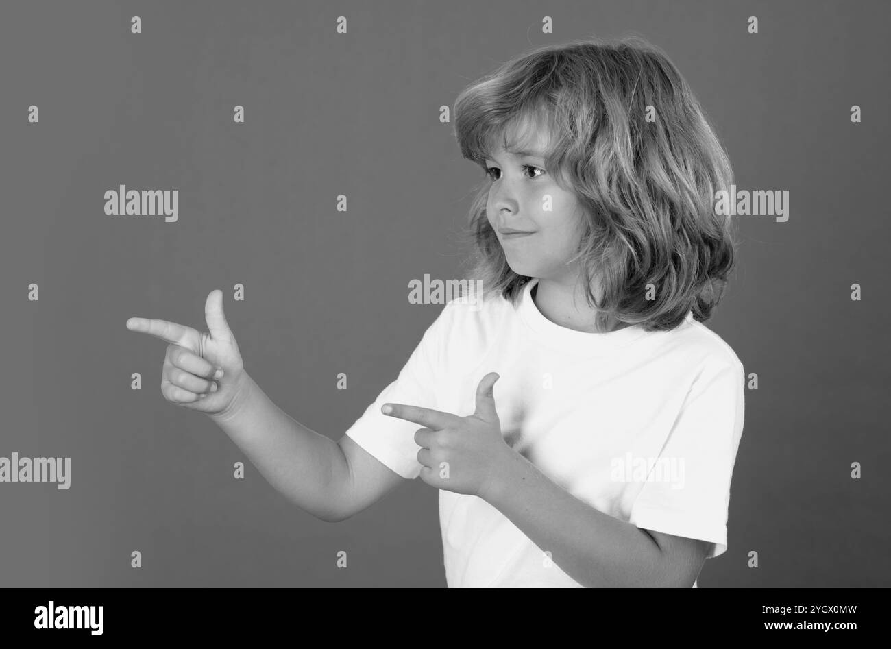 Cute child pointing finger on isolated studio background. Kid pointing ...