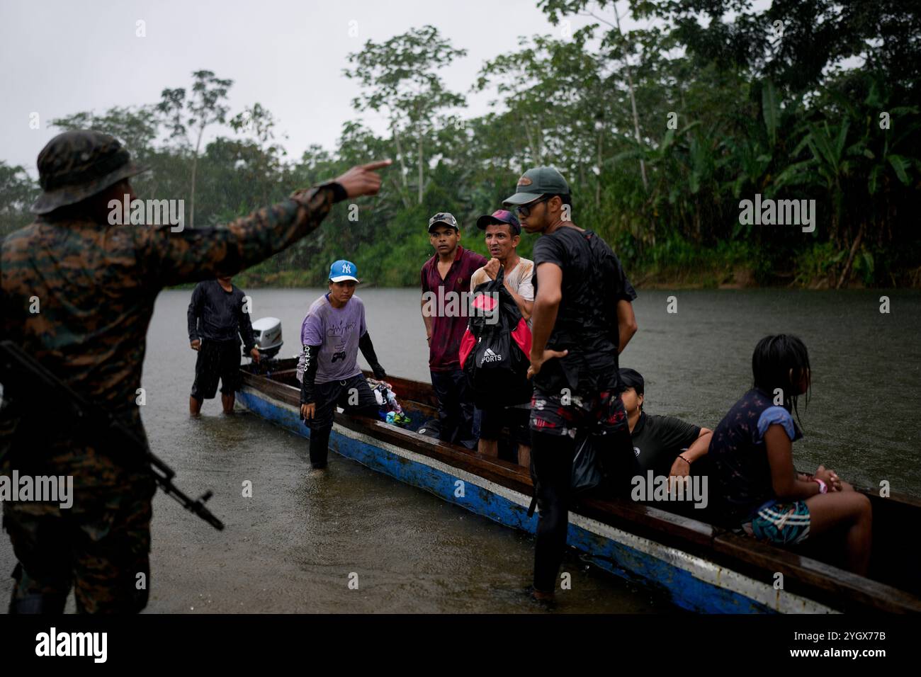 a Panamanian border police talks to Colombian migrants who boarded a ...