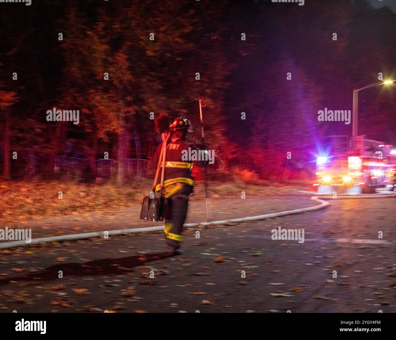 A firefighter carries shovels as he responds to the November 8, 2024 ...
