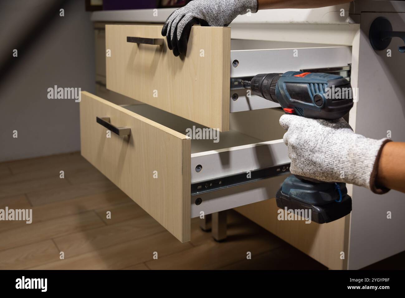 Worker fix over tight drawer slides in kitchen. Concept Fix stuck ...