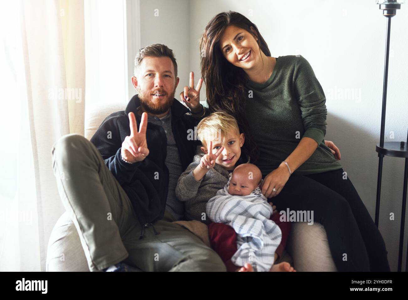 Peace sign, portrait and parents with children in home with love, care ...