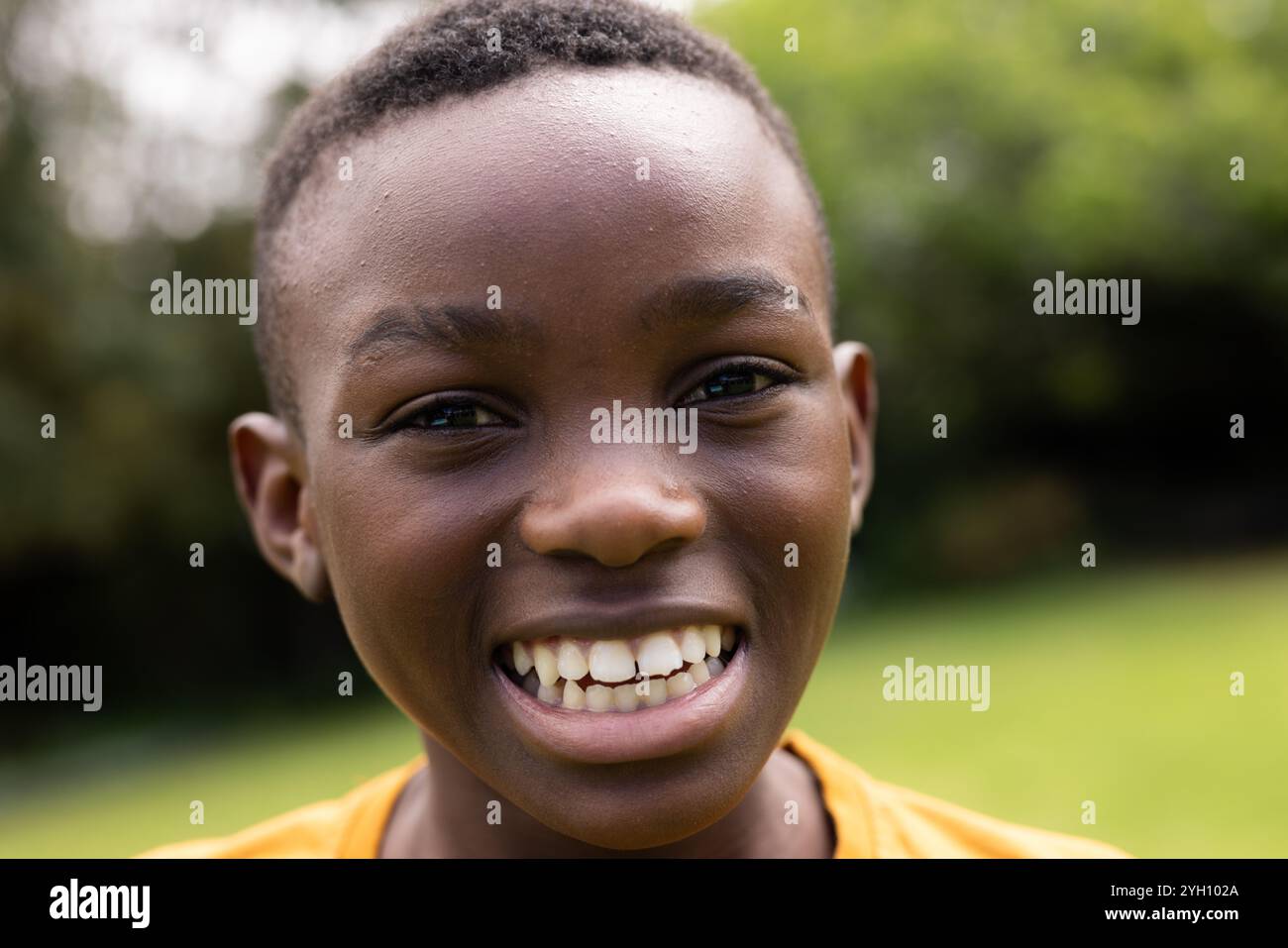 Smiling boy enjoying outdoor time in sunny garden, feeling joyful and ...