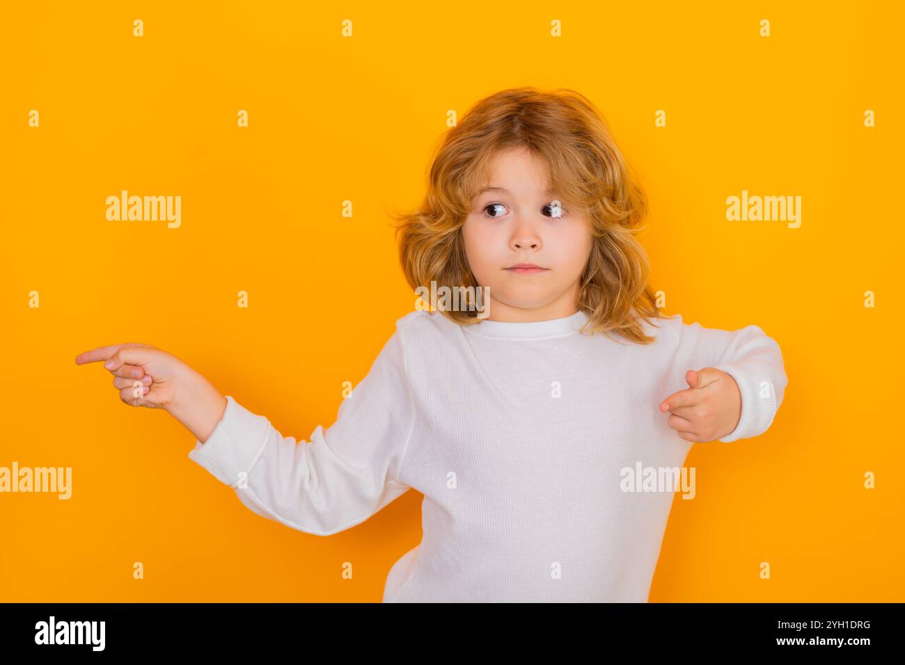 Surprised child pointing finger on isolated studio background. Shocked ...