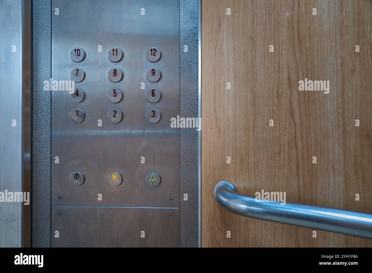 Round metallic buttons on a 12 storey elevator control panel with ...
