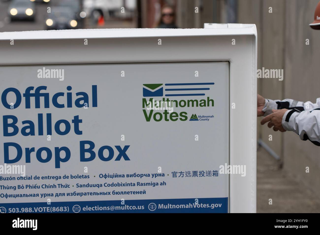 A voter walks up to a ballot drop box and casts his vote outside of the ...