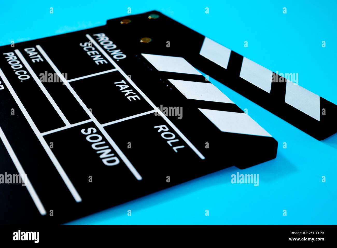 Close up of black wooden movie clapperboard on a blue background, cinematography tool concept ...