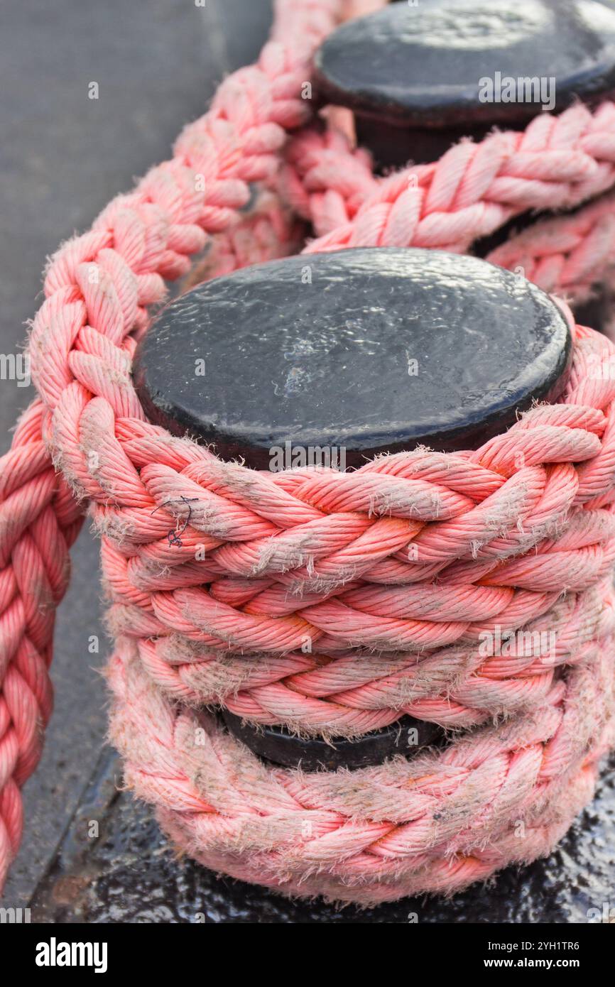 Thick rope and black mooring bollard. Detail and part of port. Yachting ...