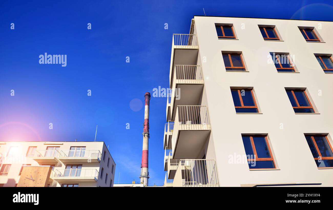 Multi storey building and factory chimney. New multi-storey facade ...
