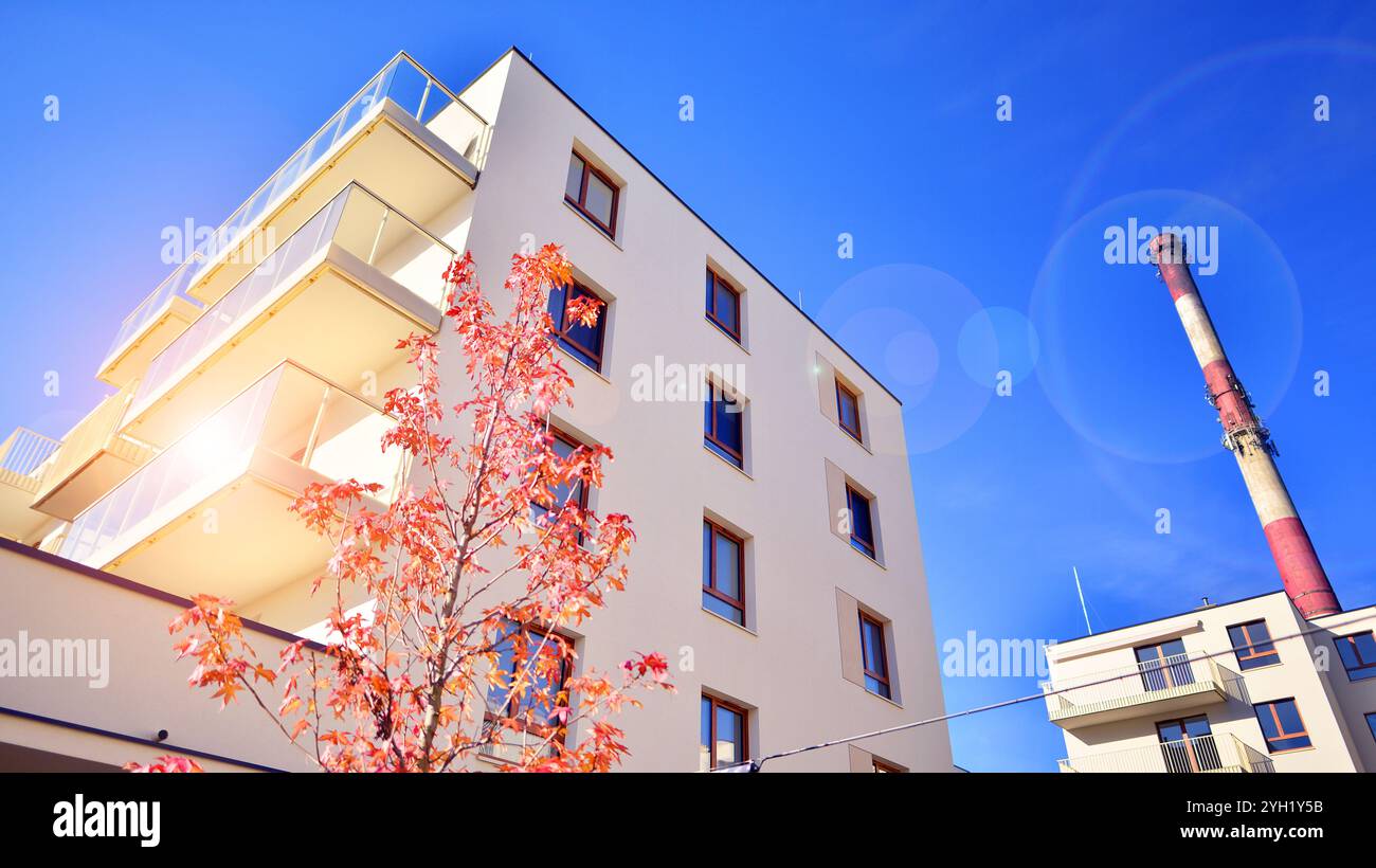 Multi storey building and factory chimney. New multi-storey facade ...