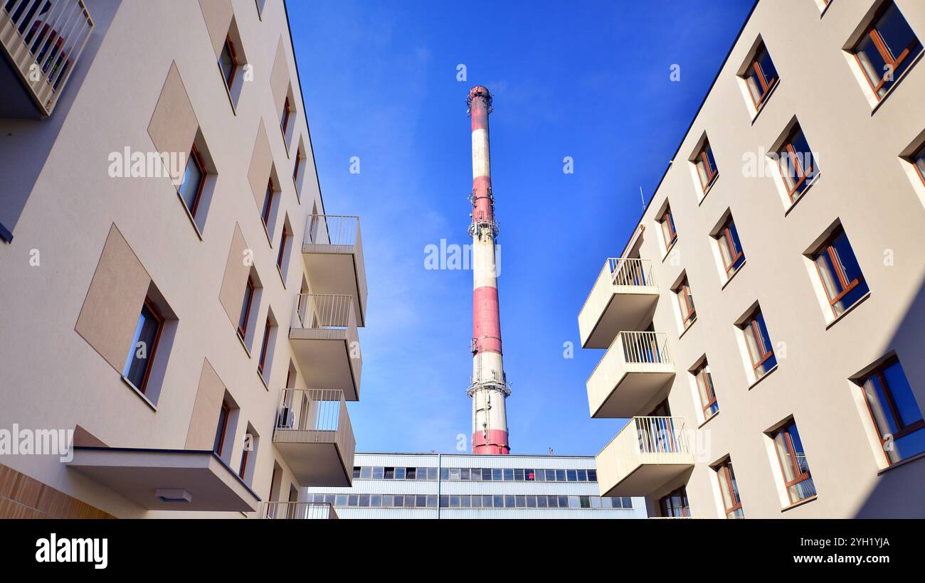 Multi storey building and factory chimney. New multi-storey facade ...