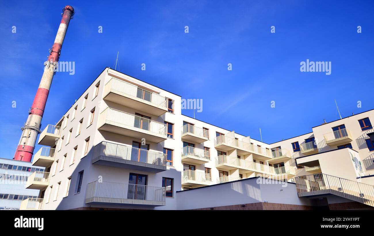 Multi storey building and factory chimney. New multi-storey facade ...