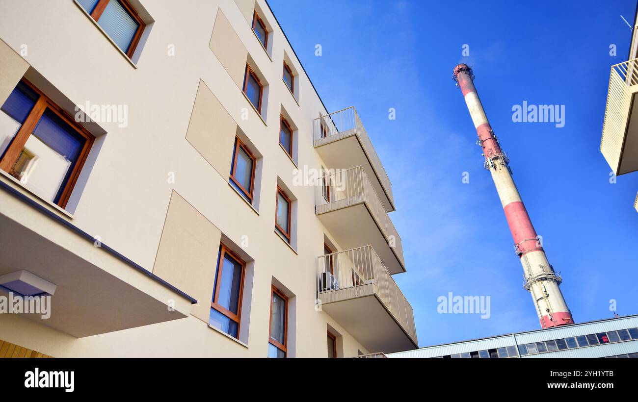 Multi storey building and factory chimney. New multi-storey facade ...