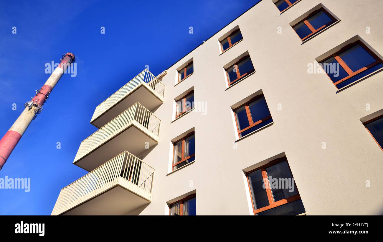 Multi storey building and factory chimney. New multi-storey facade ...