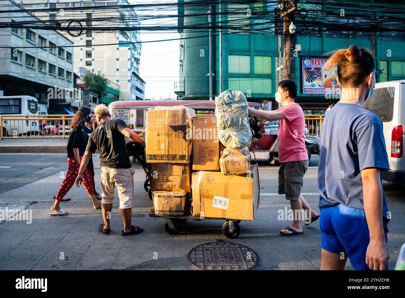 A Filipino market worker pulls his trolley along the street in a market ...
