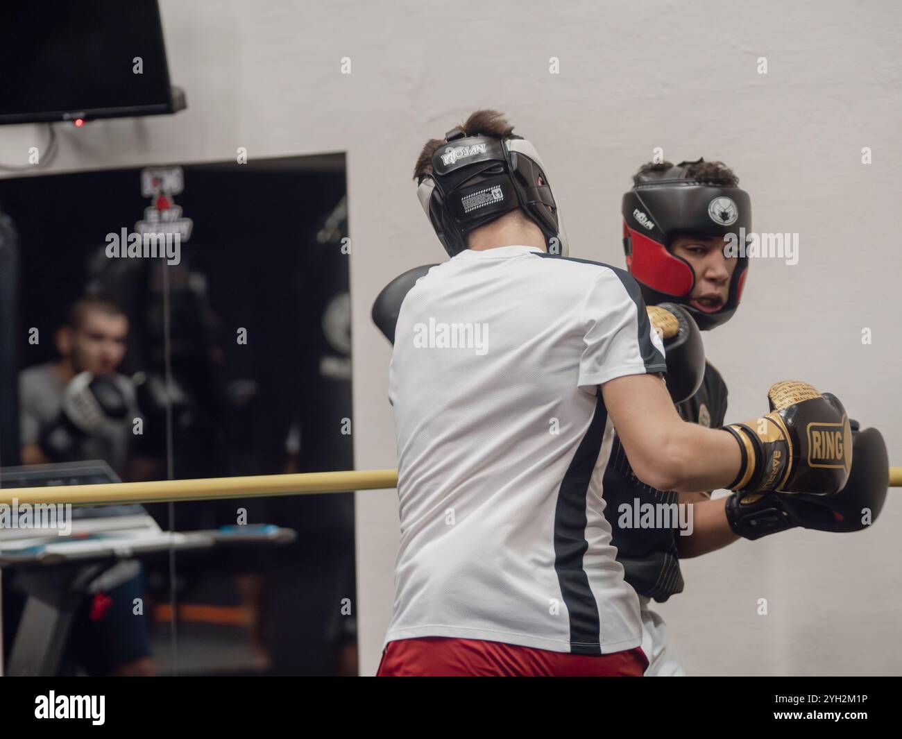 Two men are boxing in a ring. One of them is wearing a Ring glove. The ...
