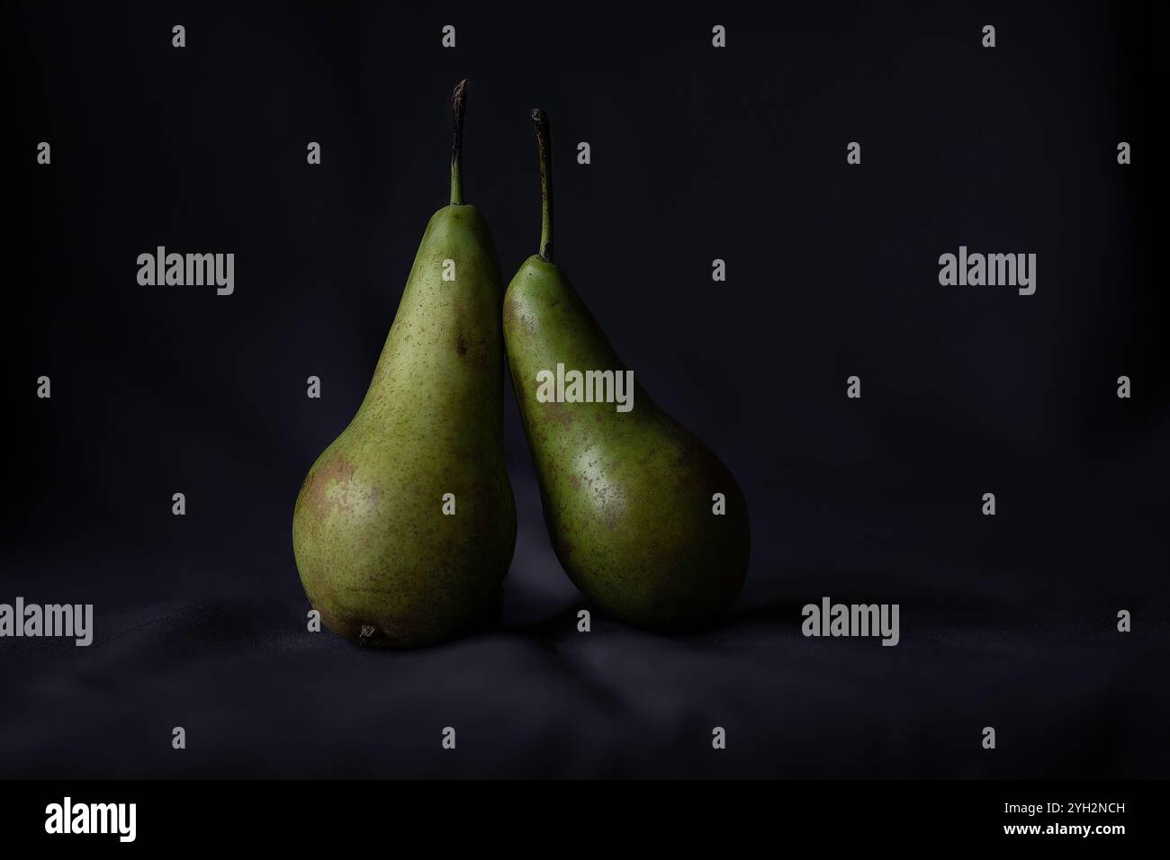 Pears positioned together against a dark background. The pears are well ...