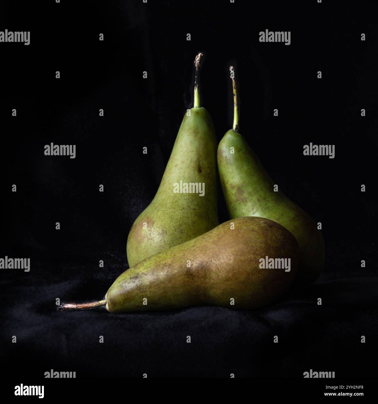 Pears positioned together against a dark background. The pears are well ...