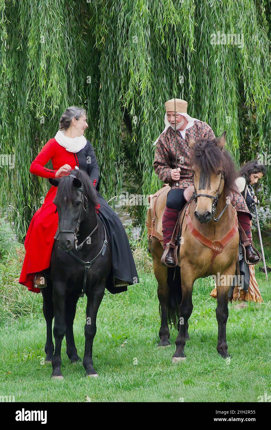 Participants in medieval costumes riding horses during a historical ...