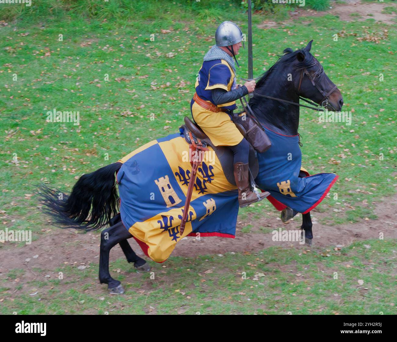 Man in medieval costume rides a caparisoned horse during a historical ...