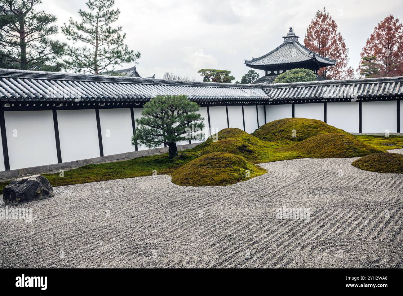 The sand in a dry garden is raked in patterns to represent waves and ...