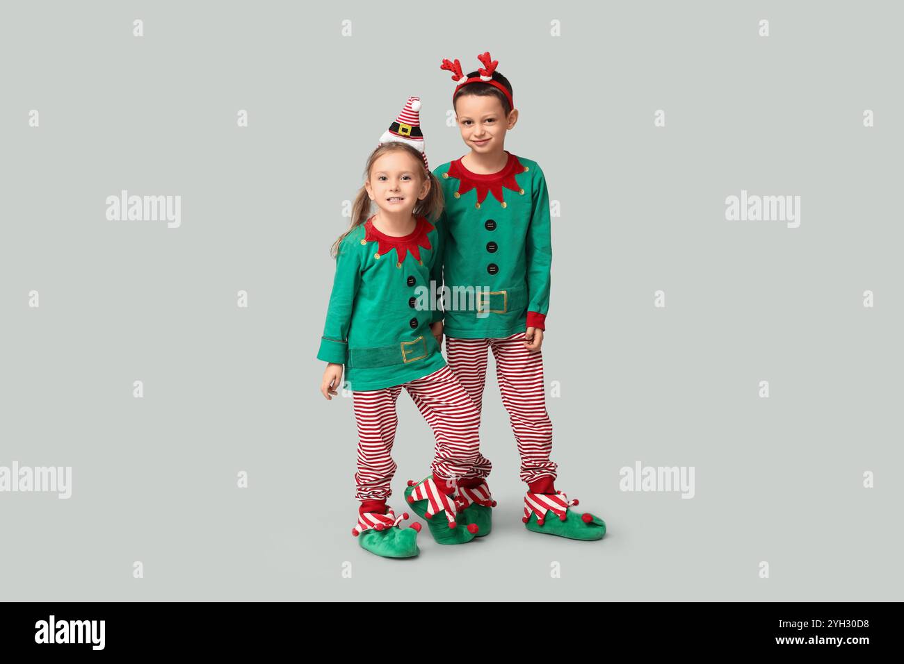 Cute little children dressed as elves on grey background Stock Photo ...