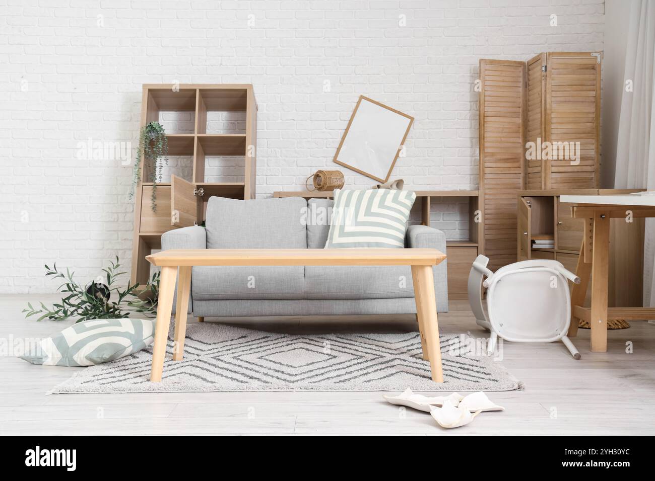 Interior of messy living room with sofa and tables after earthquake ...
