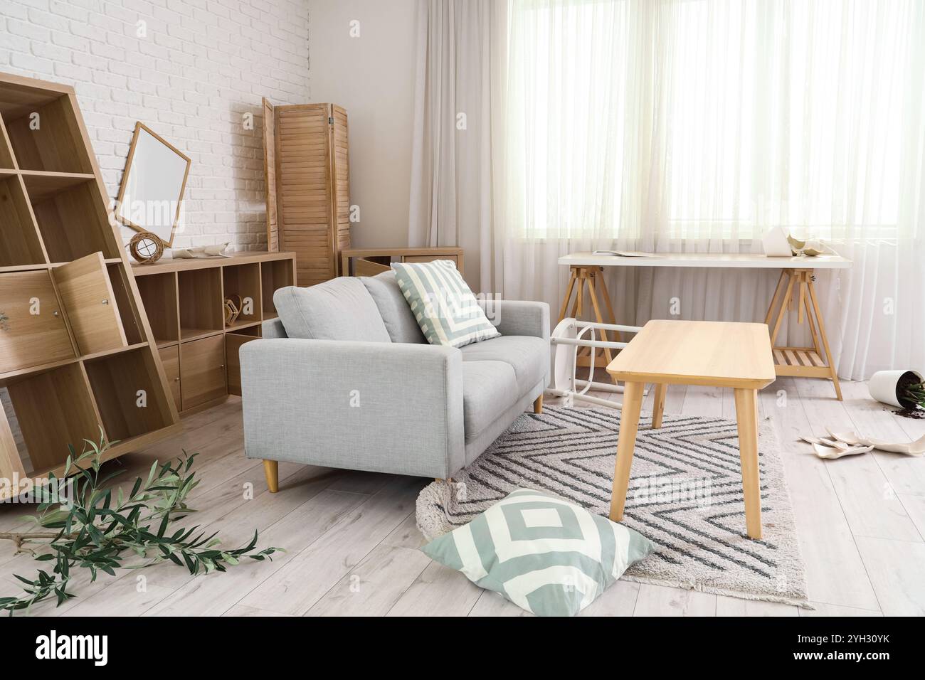 Interior of messy living room with sofa and tables after earthquake ...