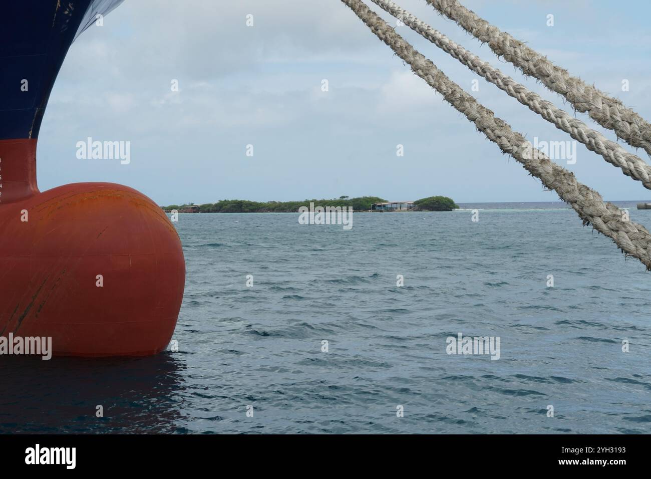 Head lines come out from bow of container vessel with blue hull and red ...