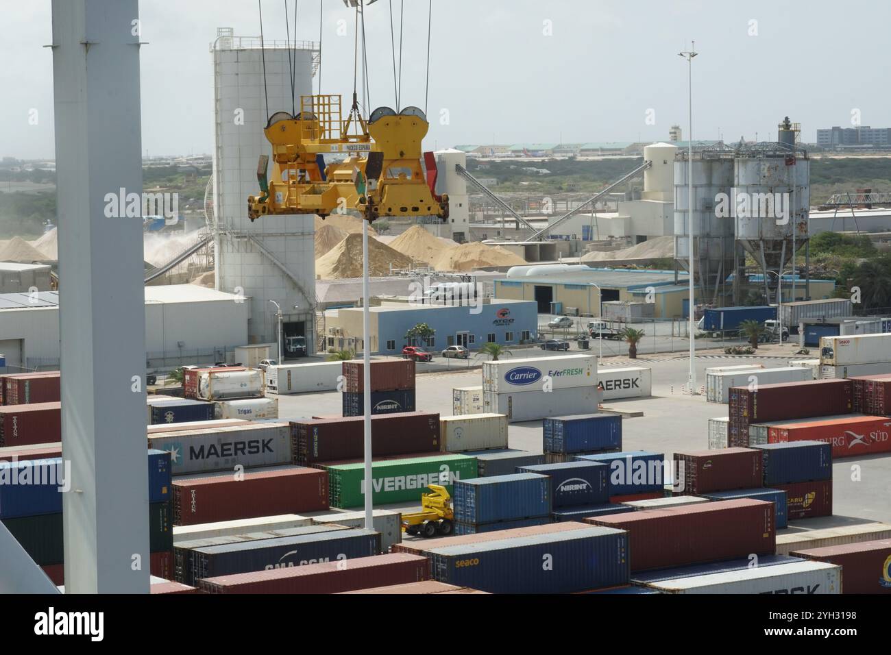 Yellow spreader of gray gantry crane on rails using for loading and ...