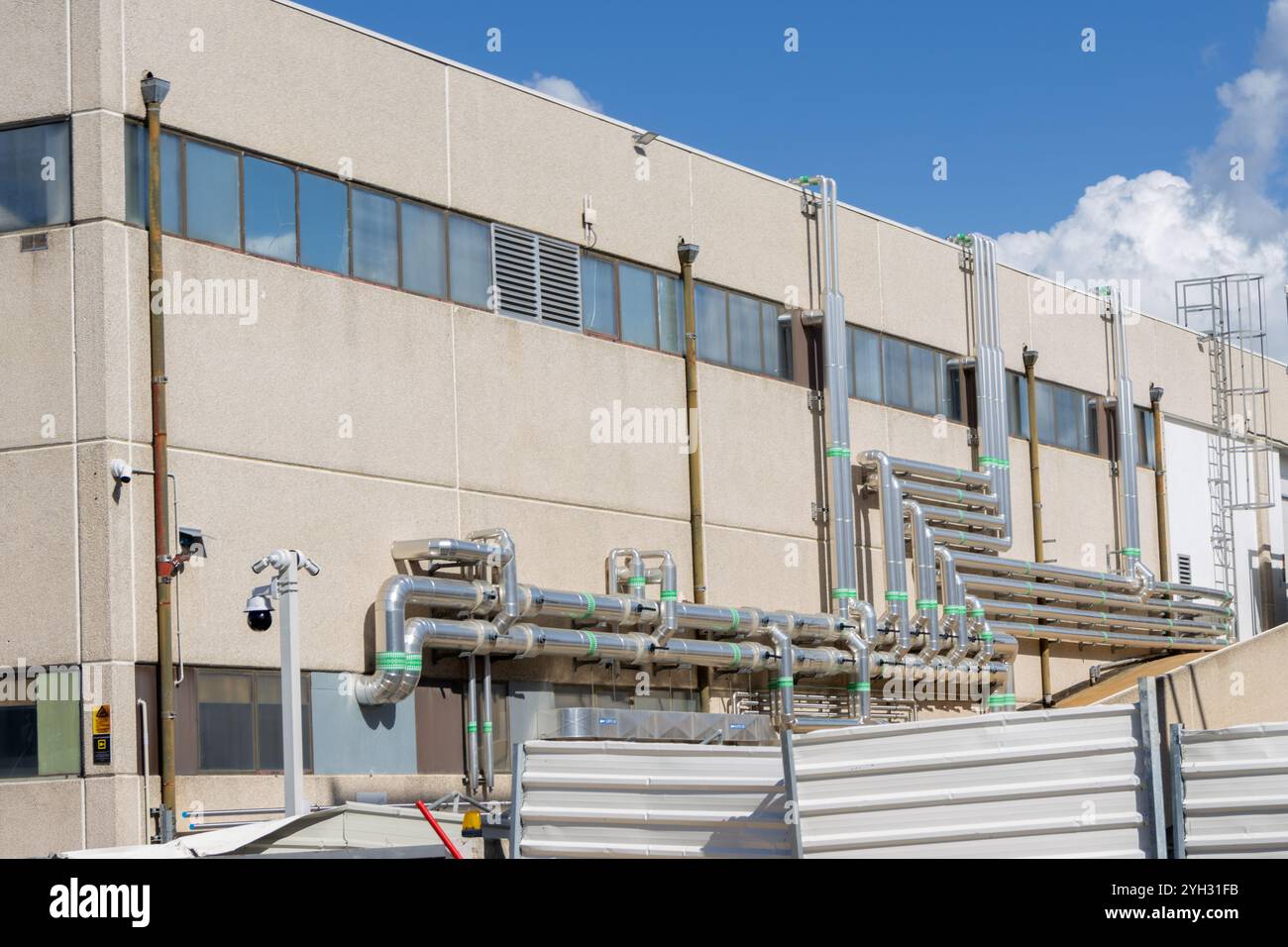 Metal ventilation pipes and ducting attached to the exterior wall of a ...