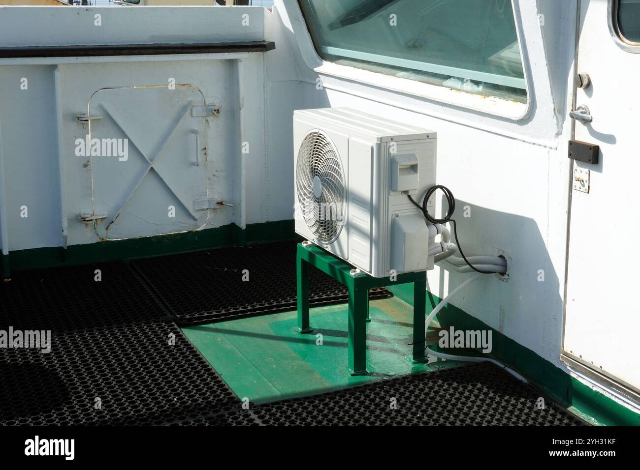 A white air conditioner is mounted on the bridge wing of a docked ...