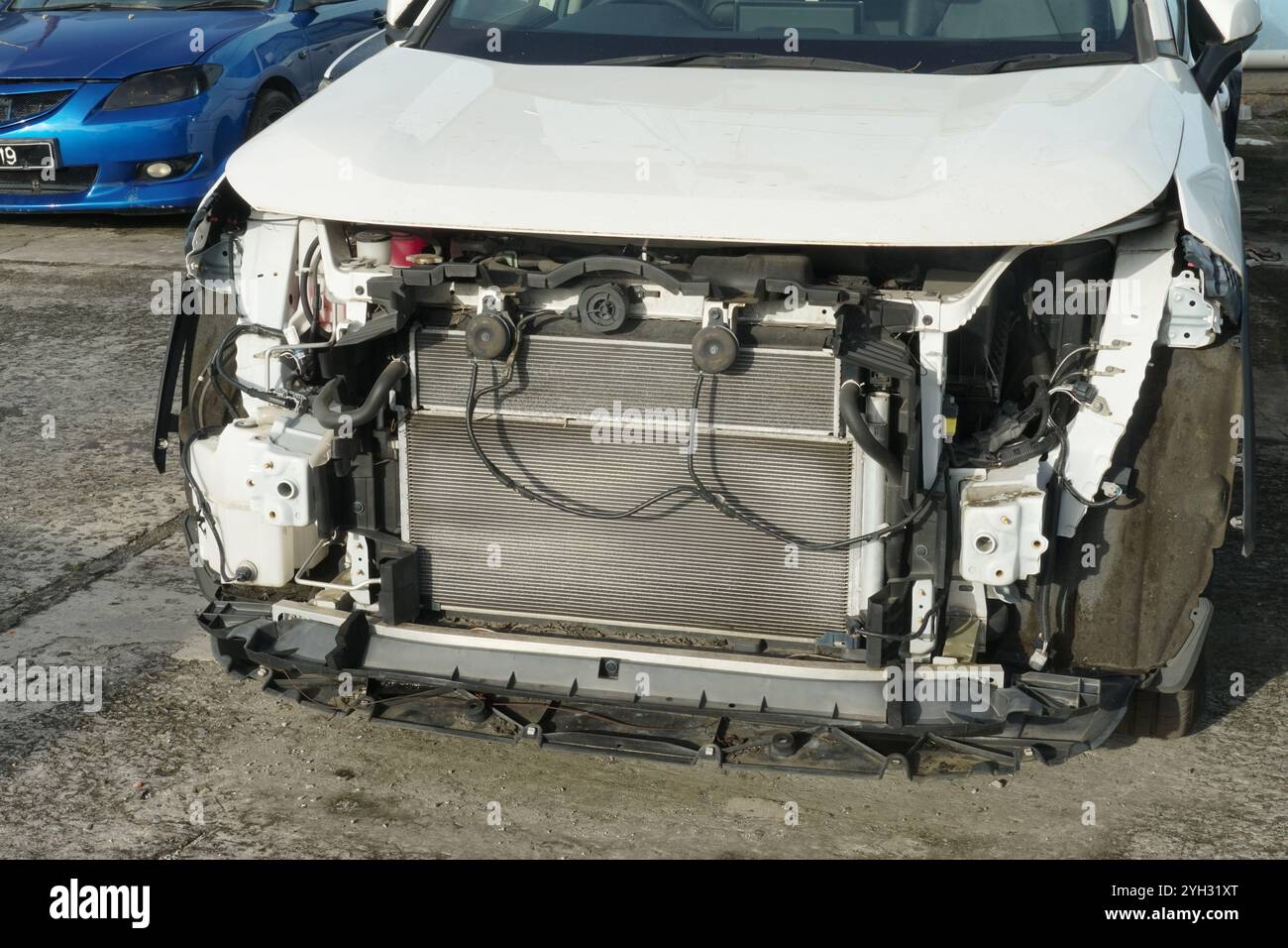 The white car's front grill and bonnet are damaged. The fender, bumper ...