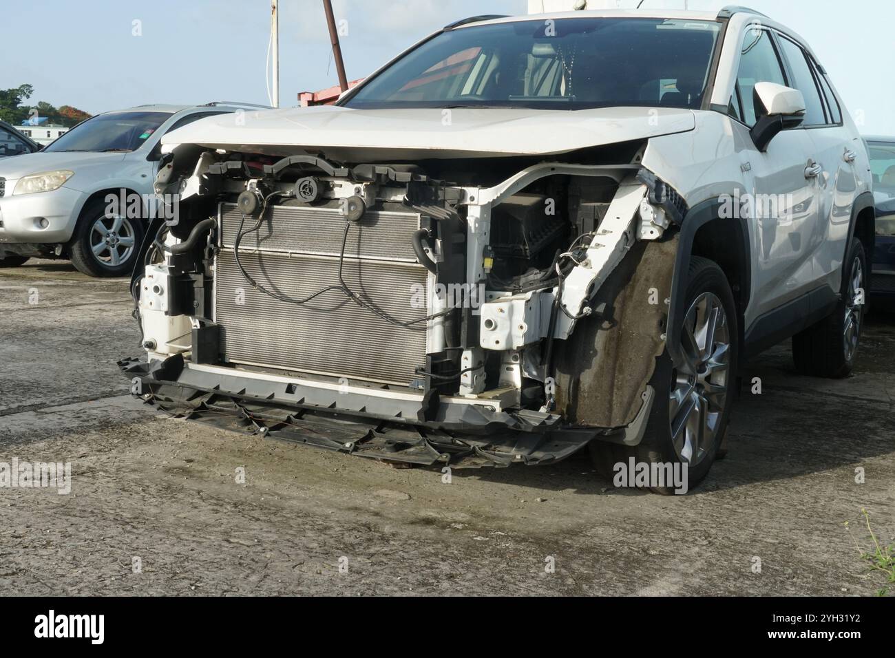 The front grill and bonnet of the white car are damaged, and it is ...