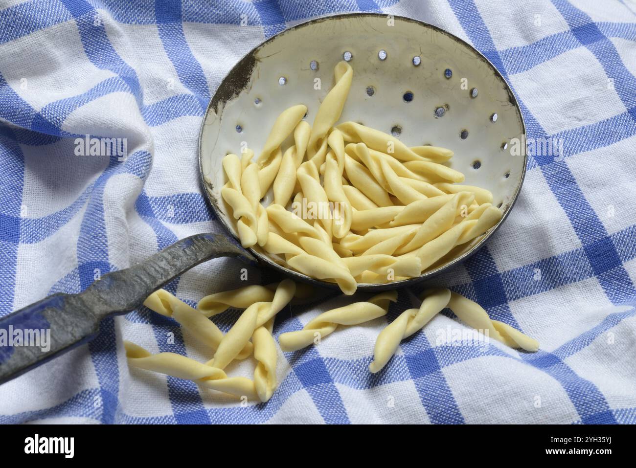 Strozzapreti, uncooked Italian pasta in a sieve, Italy, Europe Stock ...