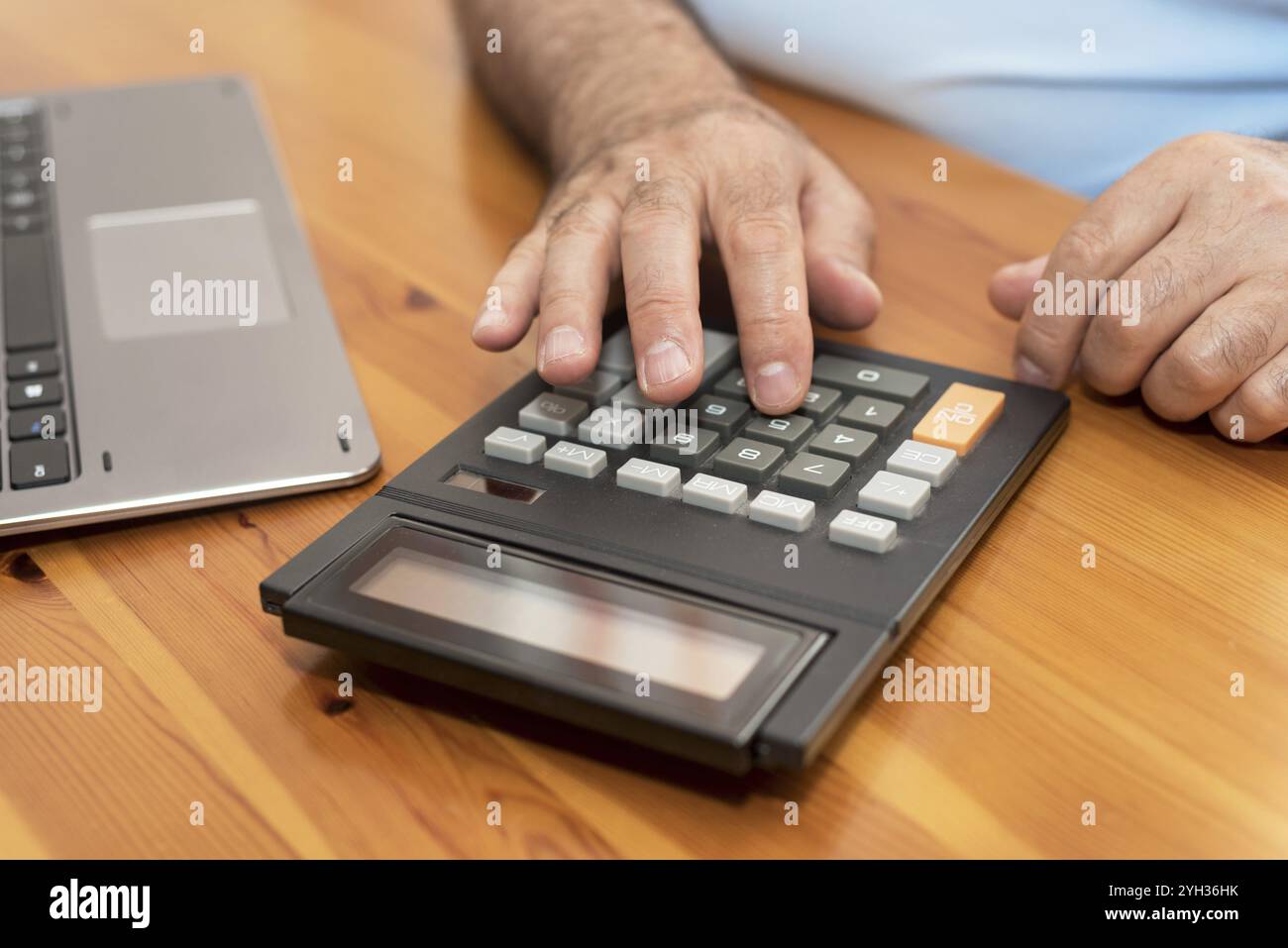 Man using calculator, calculating bills at home Stock Photo - Alamy