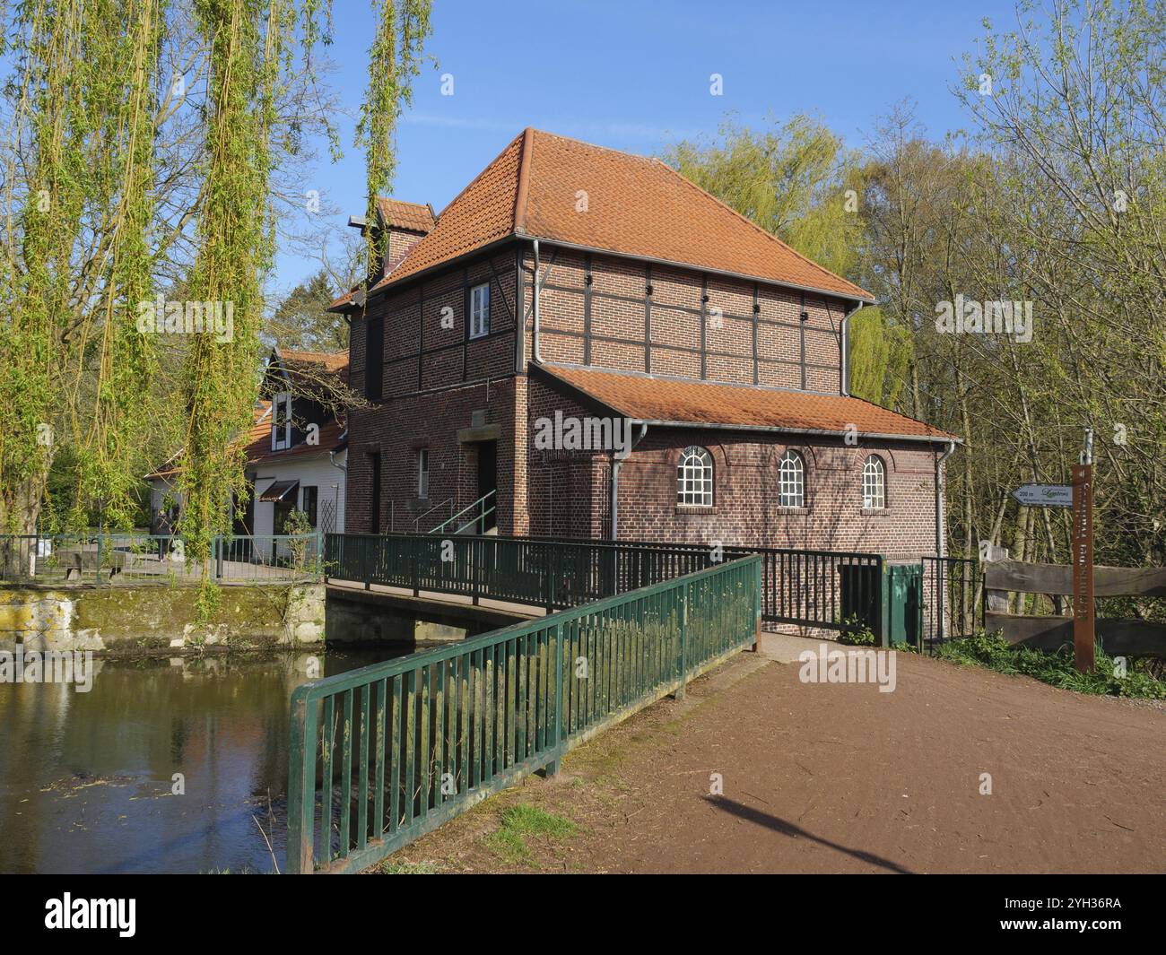 Brick mill with bridge, red roof and surrounding river, metelen ...