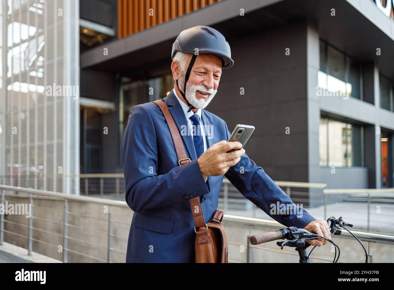 Successful old businessman with helmet reading messages over smart ...