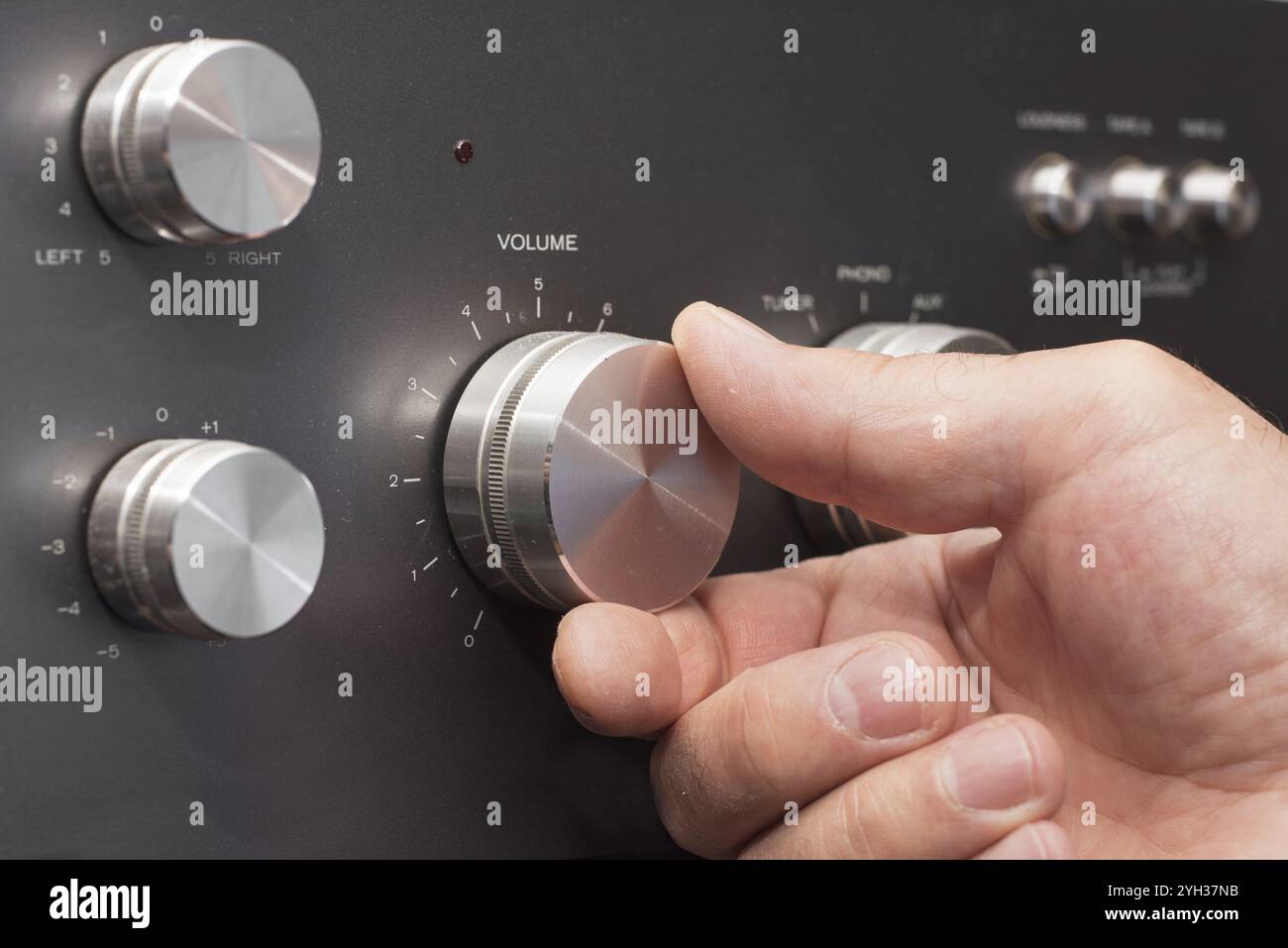Hand turning up the volume in a stereo Stock Photo - Alamy