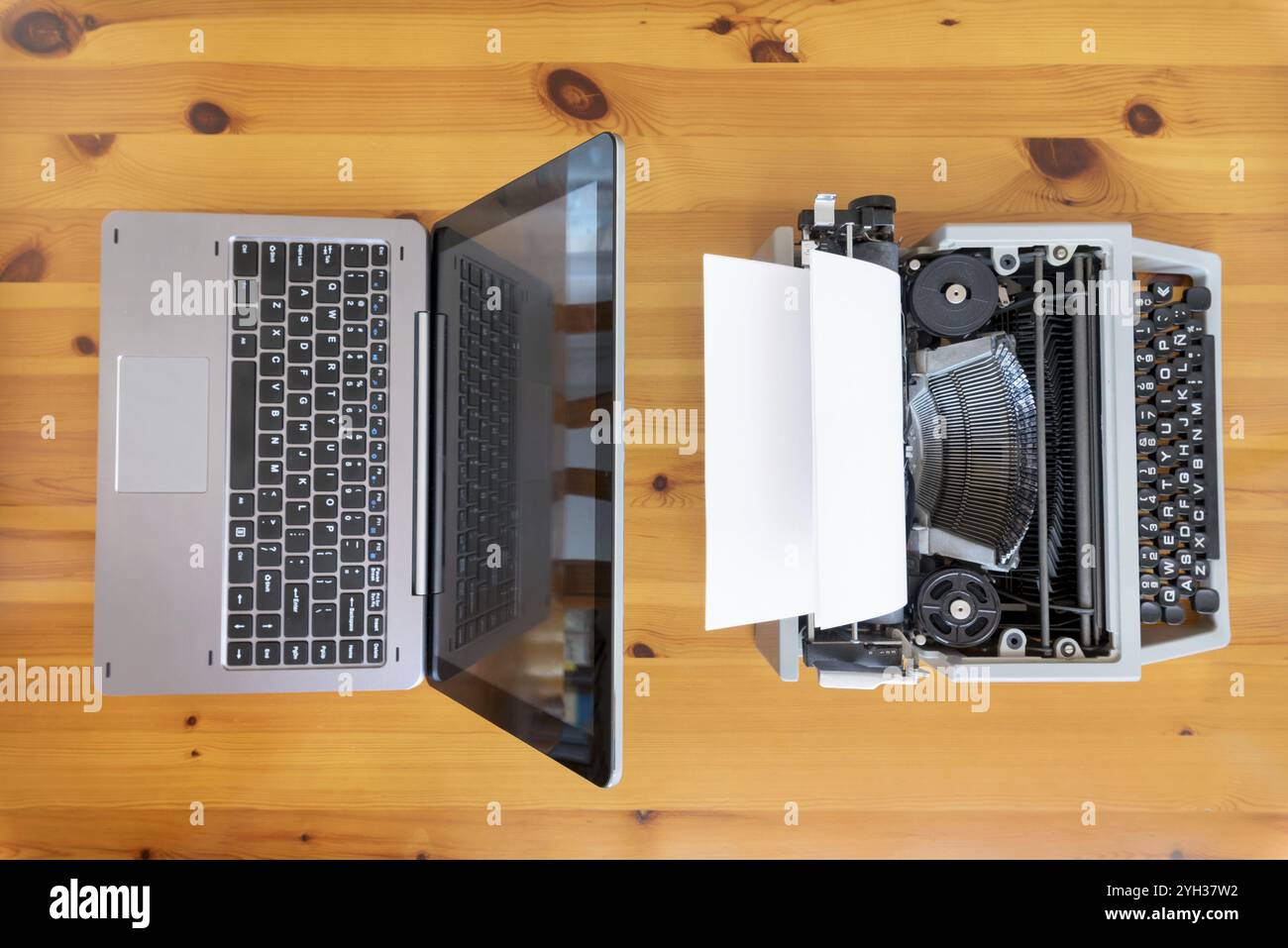 Old typewriter vs new laptop on the table. Concept of technology ...