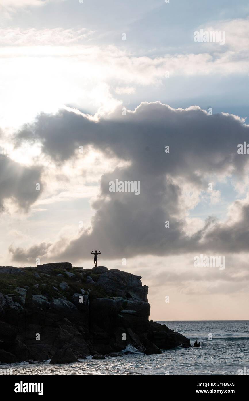 Silhouettes of human figures backlit on a sunset on a beach in the ...