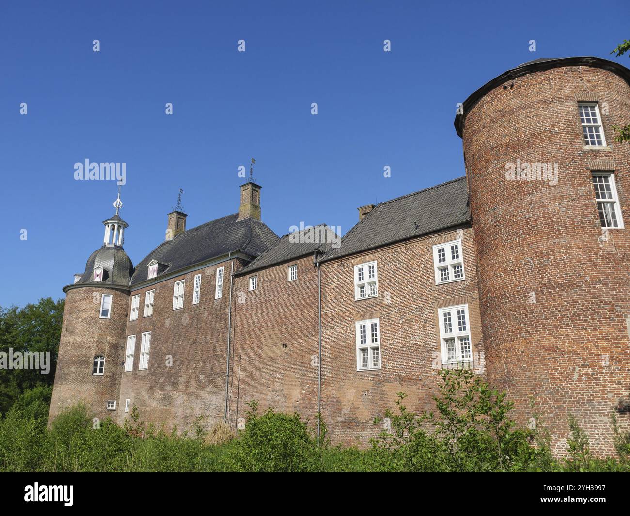 Side view of a castle with brick facade and several windows in green ...