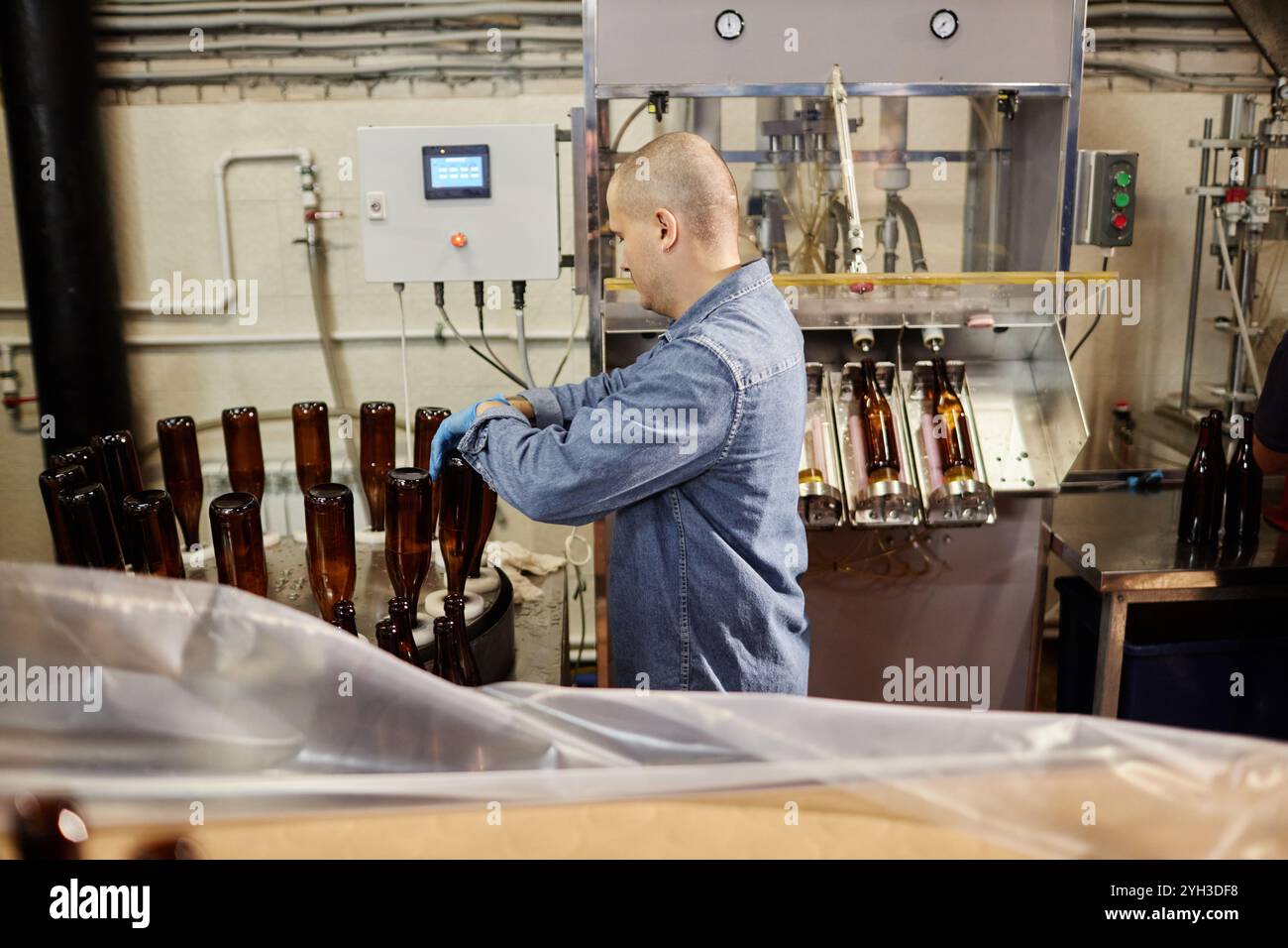 Side view of concentrated male production operator carefully ...