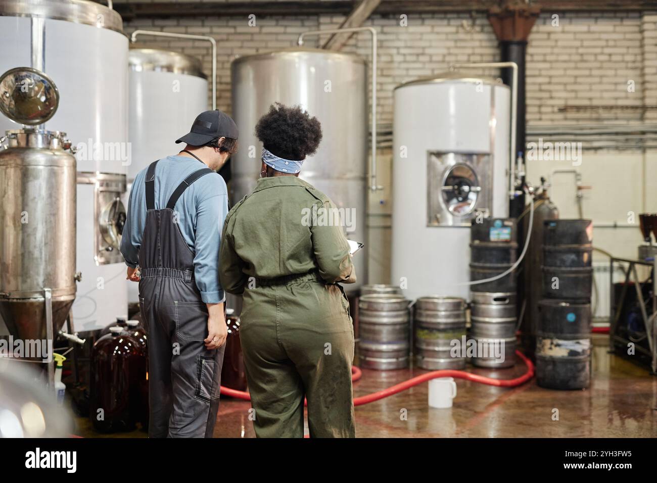 Rear view of workers at manufacture workshop operating machines Stock ...
