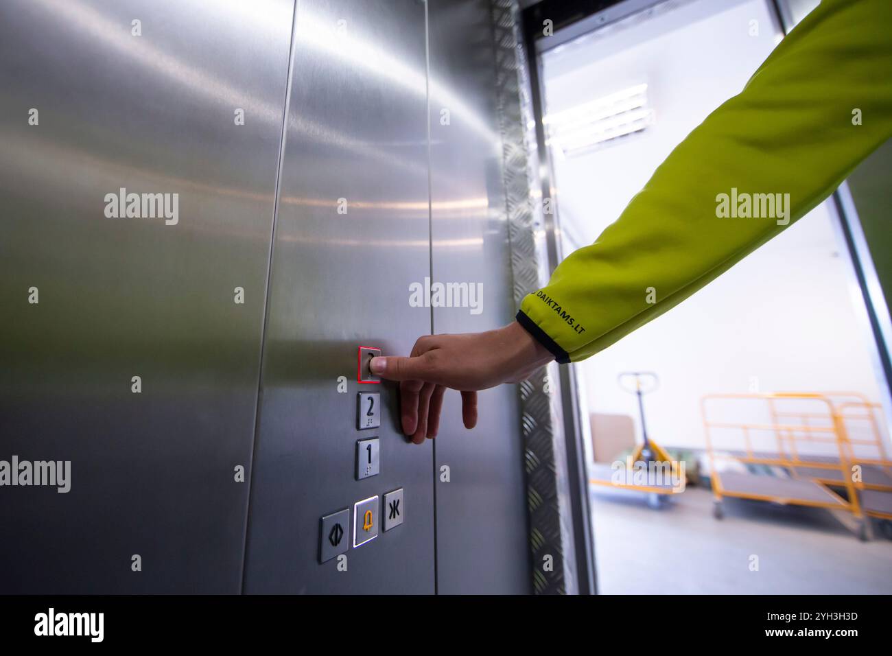 Person pressing an elevator button in a modern storage facility with ...