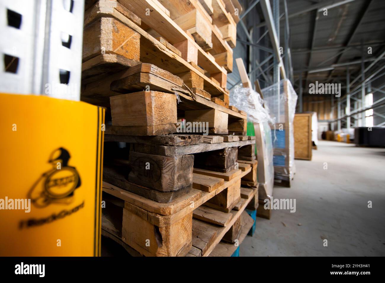 Warehouse interior with stacked wooden pallets, wrapped goods, and ...